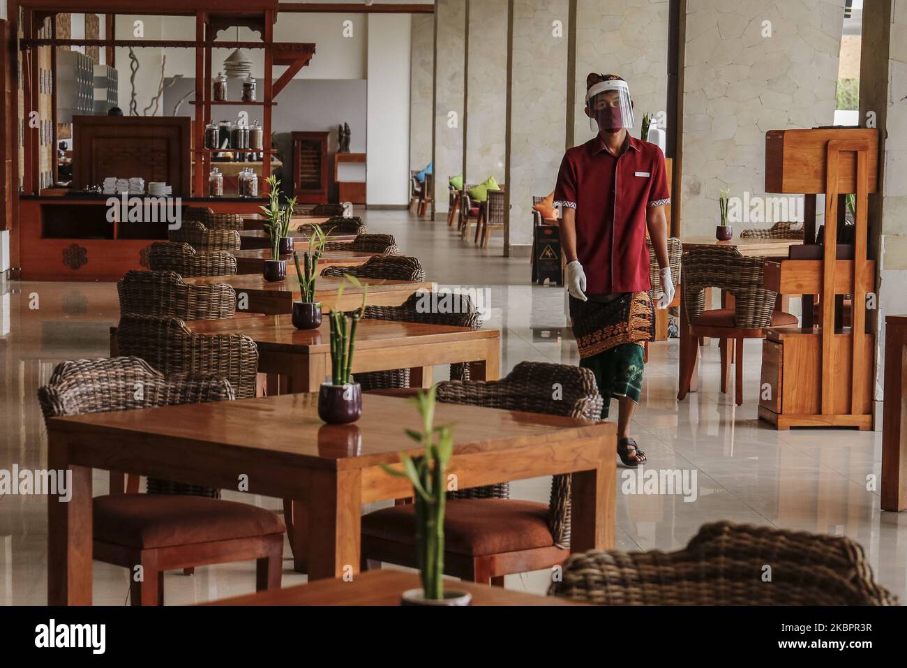 Hotel restaurant staff wearing face mask, gloves and face shield as a ...
