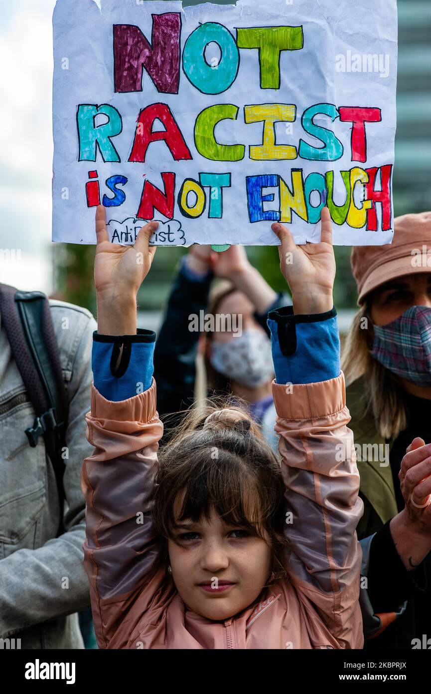A little girl is holding a big and anti racist placard, during the ...