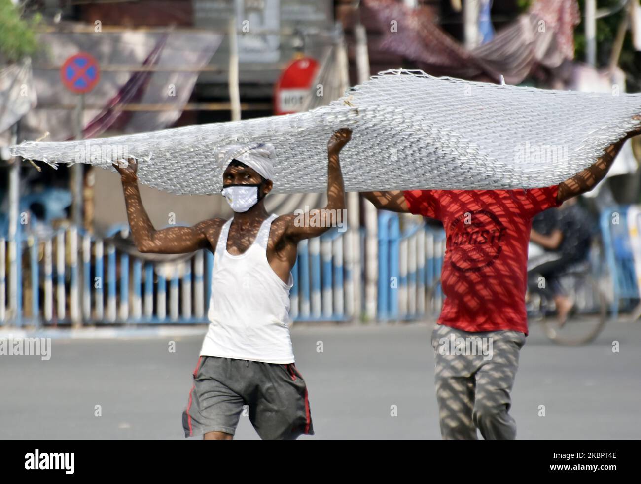 Migrant workers wearing a preventive mask against coronavirus, crosses ...