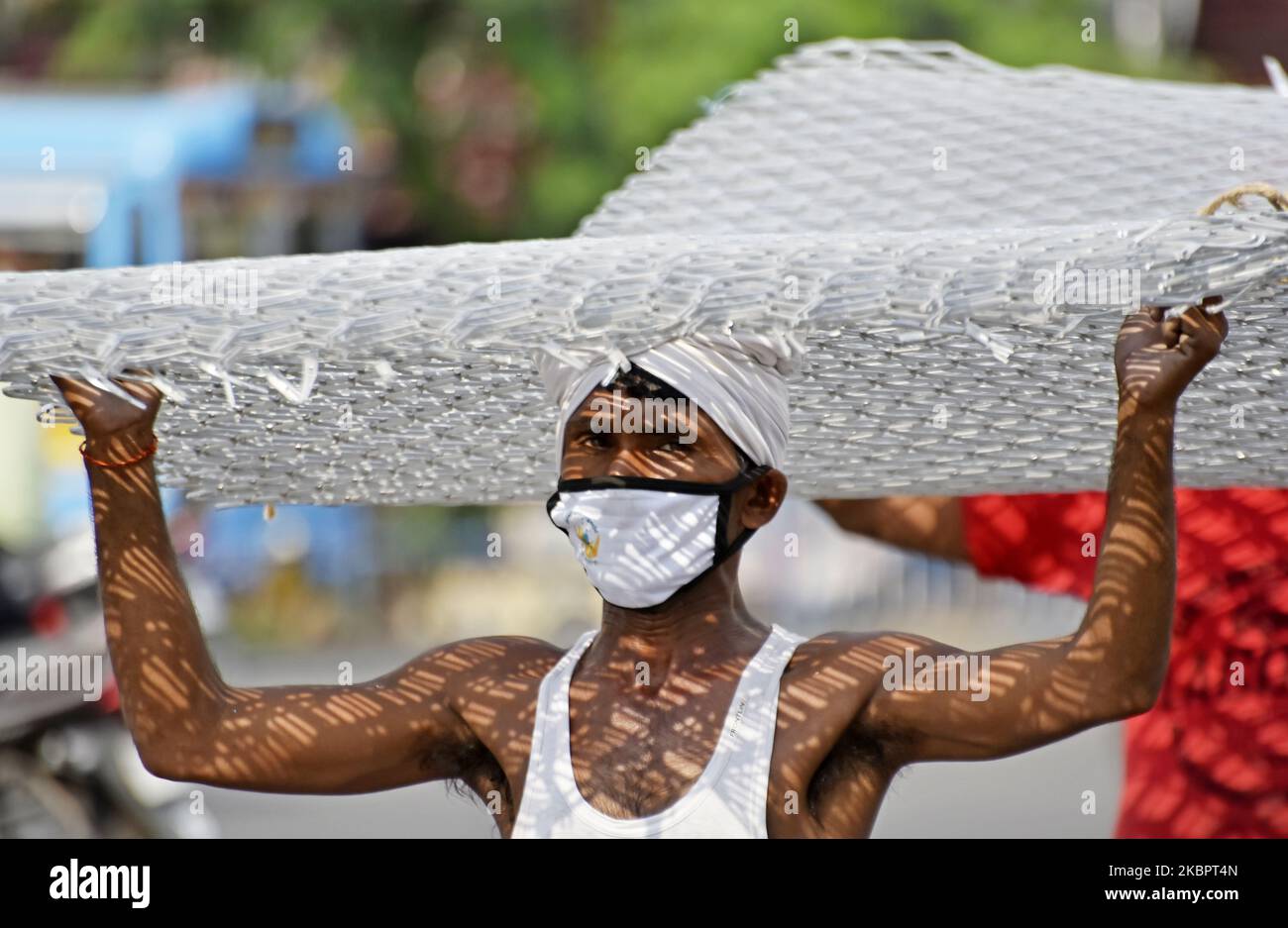 A migrant worker wears a preventive mask against coronavirus, crosses a ...