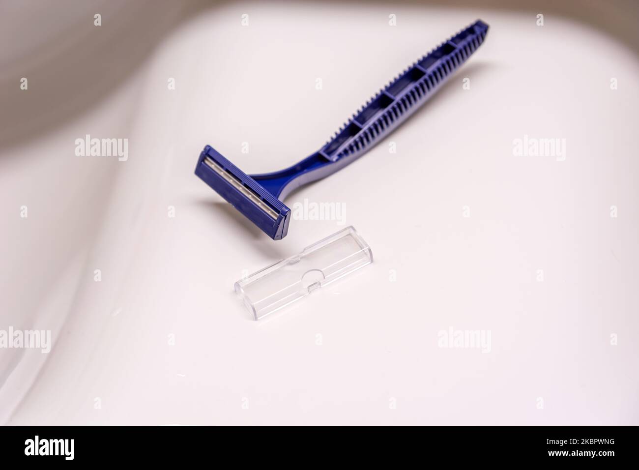 A disposable plastic blue razor lying on the sink Stock Photo - Alamy