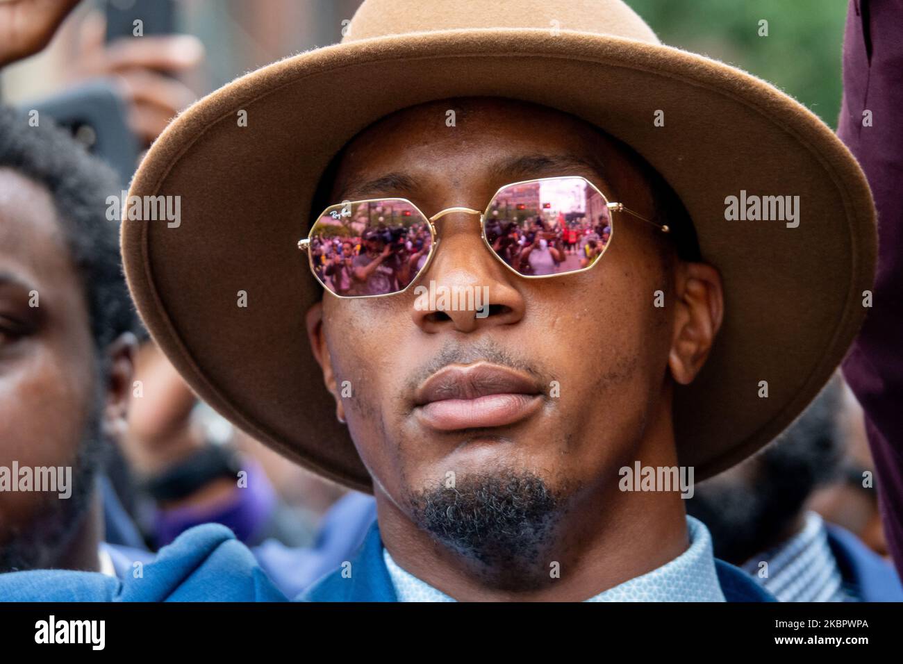 The reflection of demonstrators from Men In Pants can be seen a man’s ...