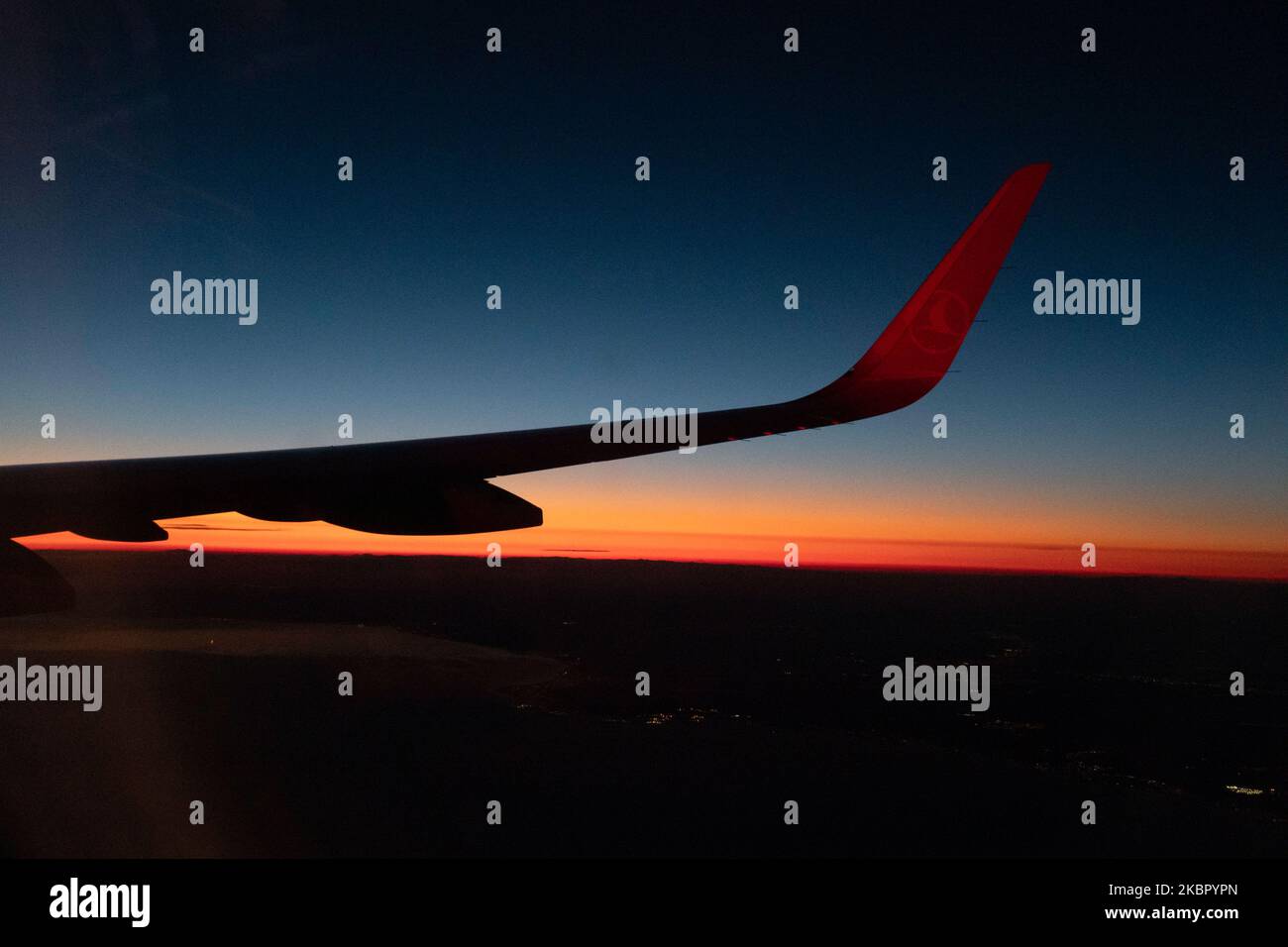 Wing view from the window of the aircraft during the magic hour - after ...