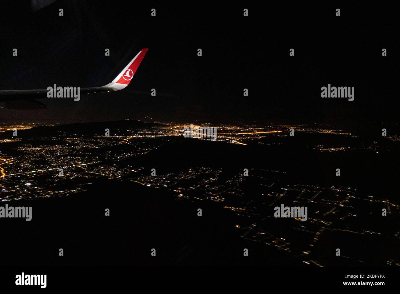 Wing view from the window of the aircraft during the magic hour - after ...