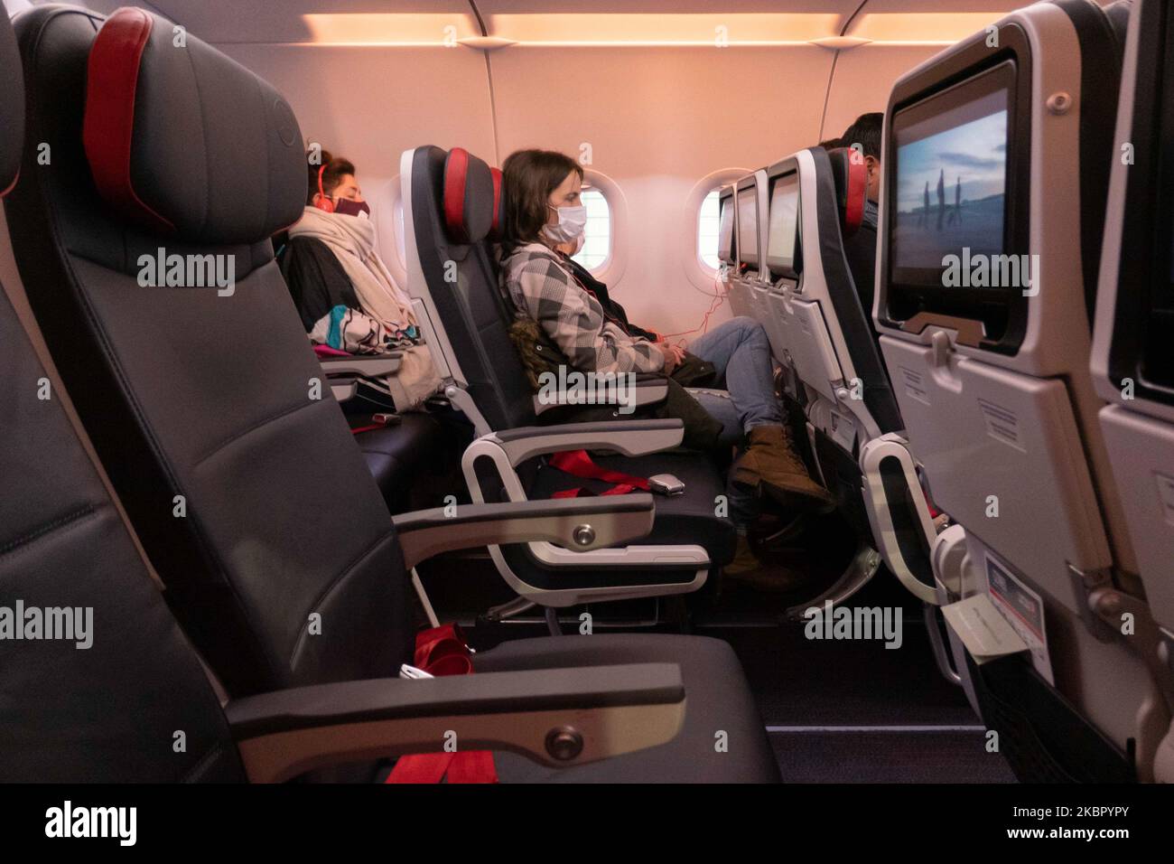 Passengers wearing protective face masks during a flight. Flying with ...