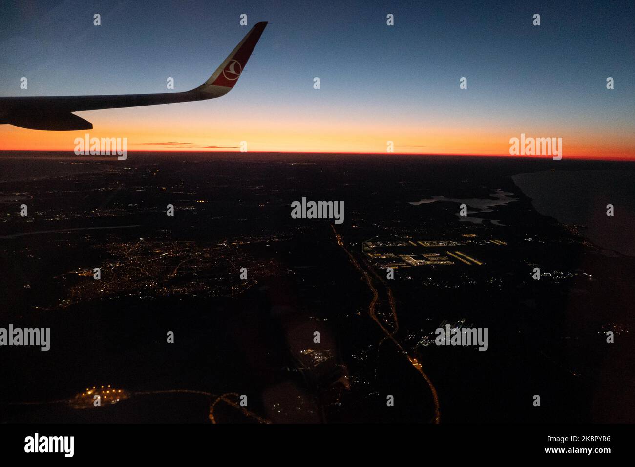 Wing view from the window of the aircraft during the magic hour - after ...