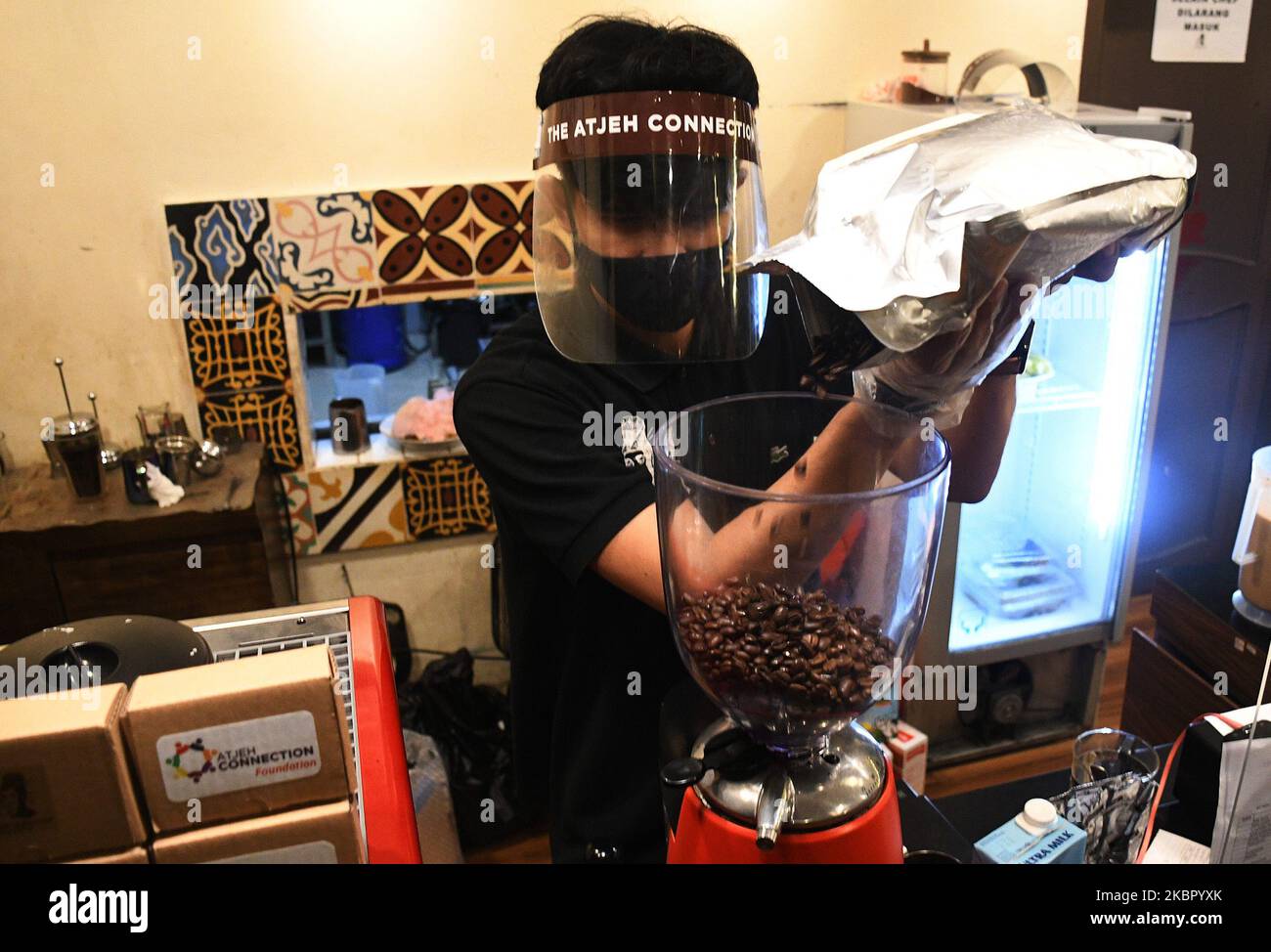 Cafe employee wearing face shield and mask works on the first day at ...