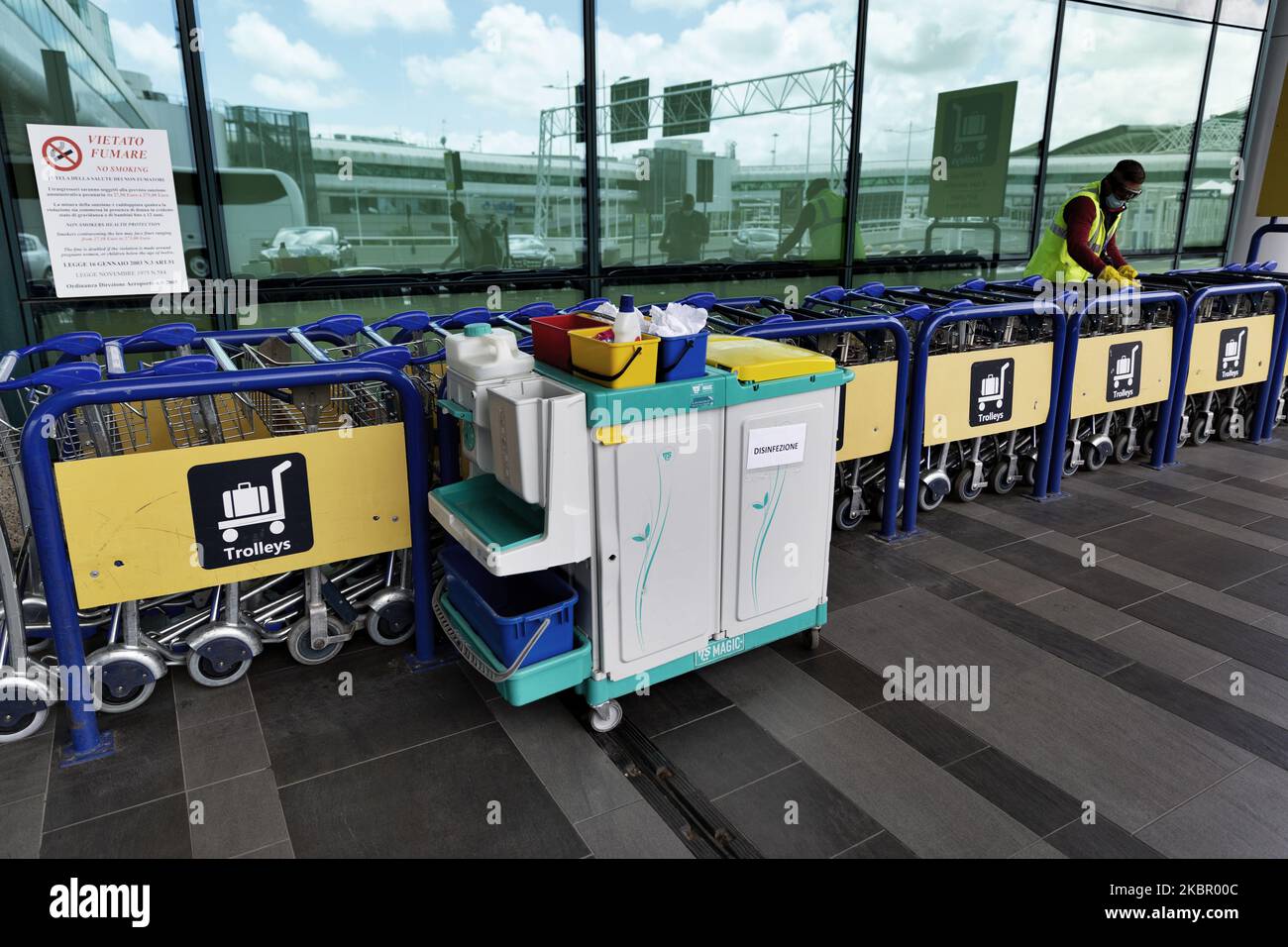 The sanification of the trolleys by a member staff outside the ...