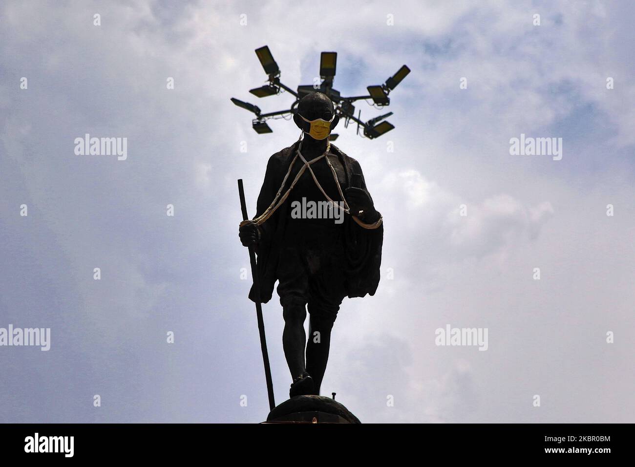 A mask is placed on a statue of Mahatma Gandhi to spread awareness ...