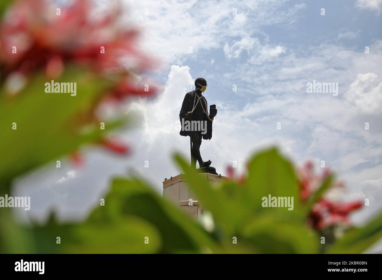 A mask is placed on a statue of Mahatma Gandhi to spread awareness ...