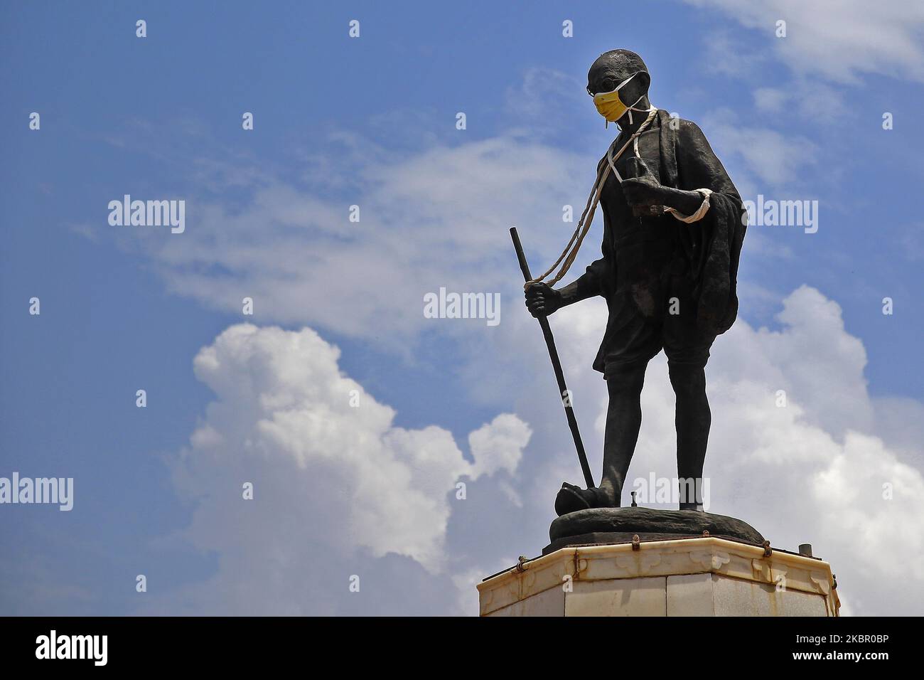 A mask is placed on a statue of Mahatma Gandhi to spread awareness ...