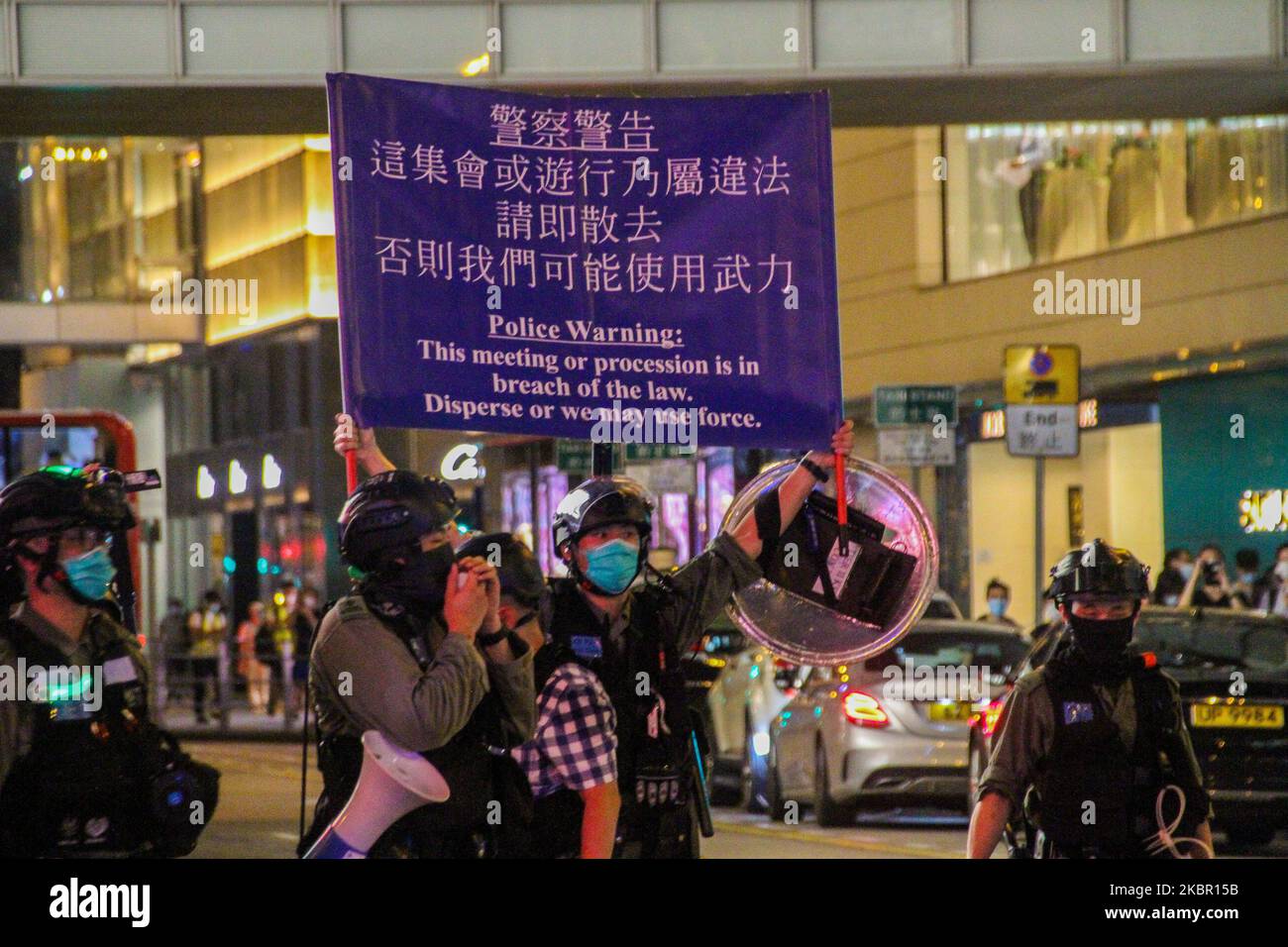 Police raise the blue flag in a warning to gathering protesters during ...