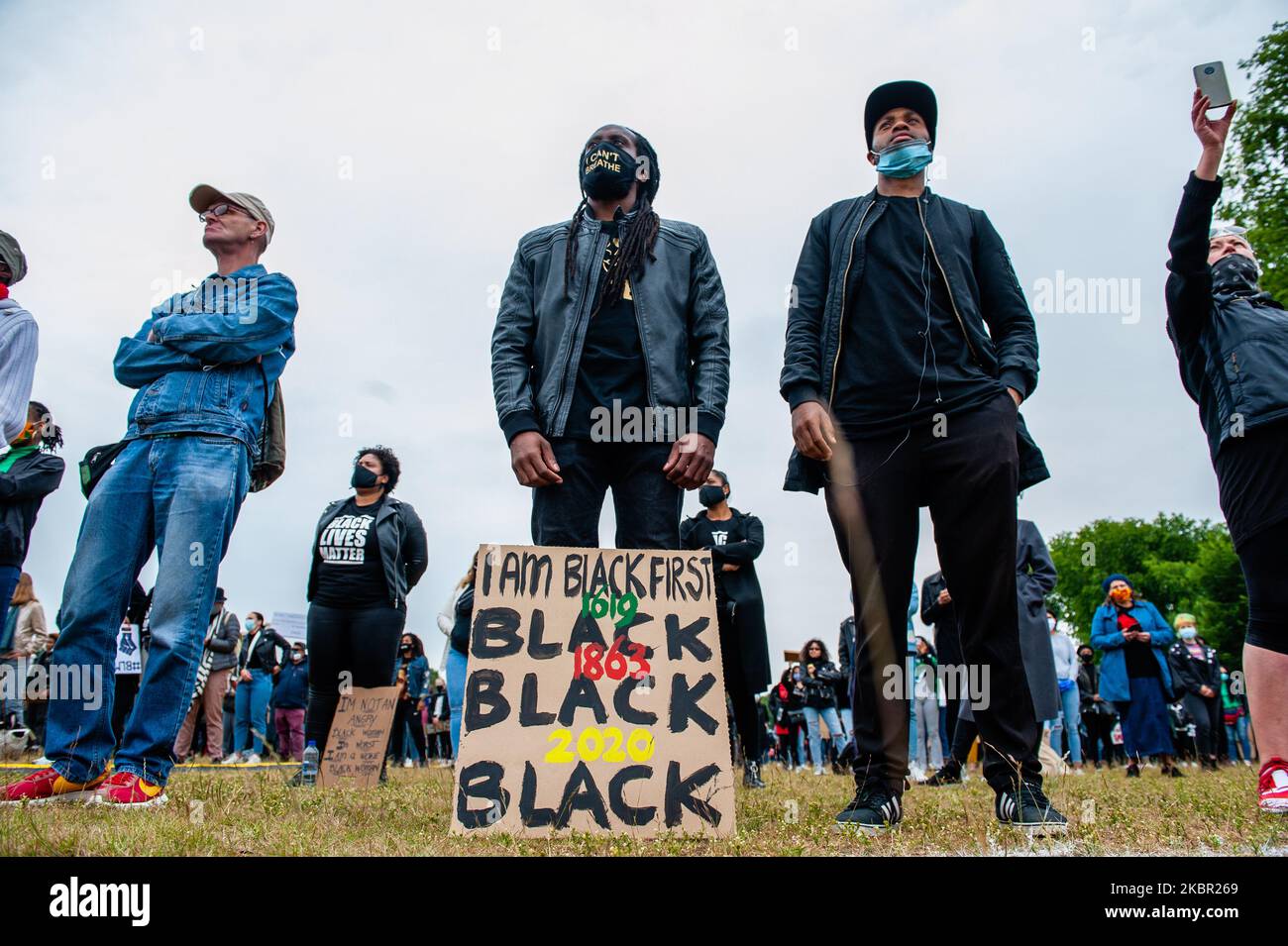 A Black man is standing up with his placard on his feet, during the ...
