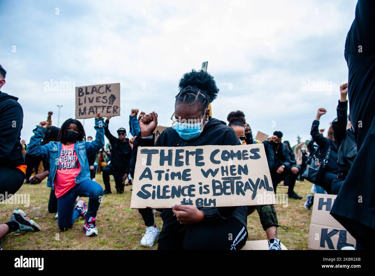 A Black woman is taking a knee, during the second massive Black Lives ...