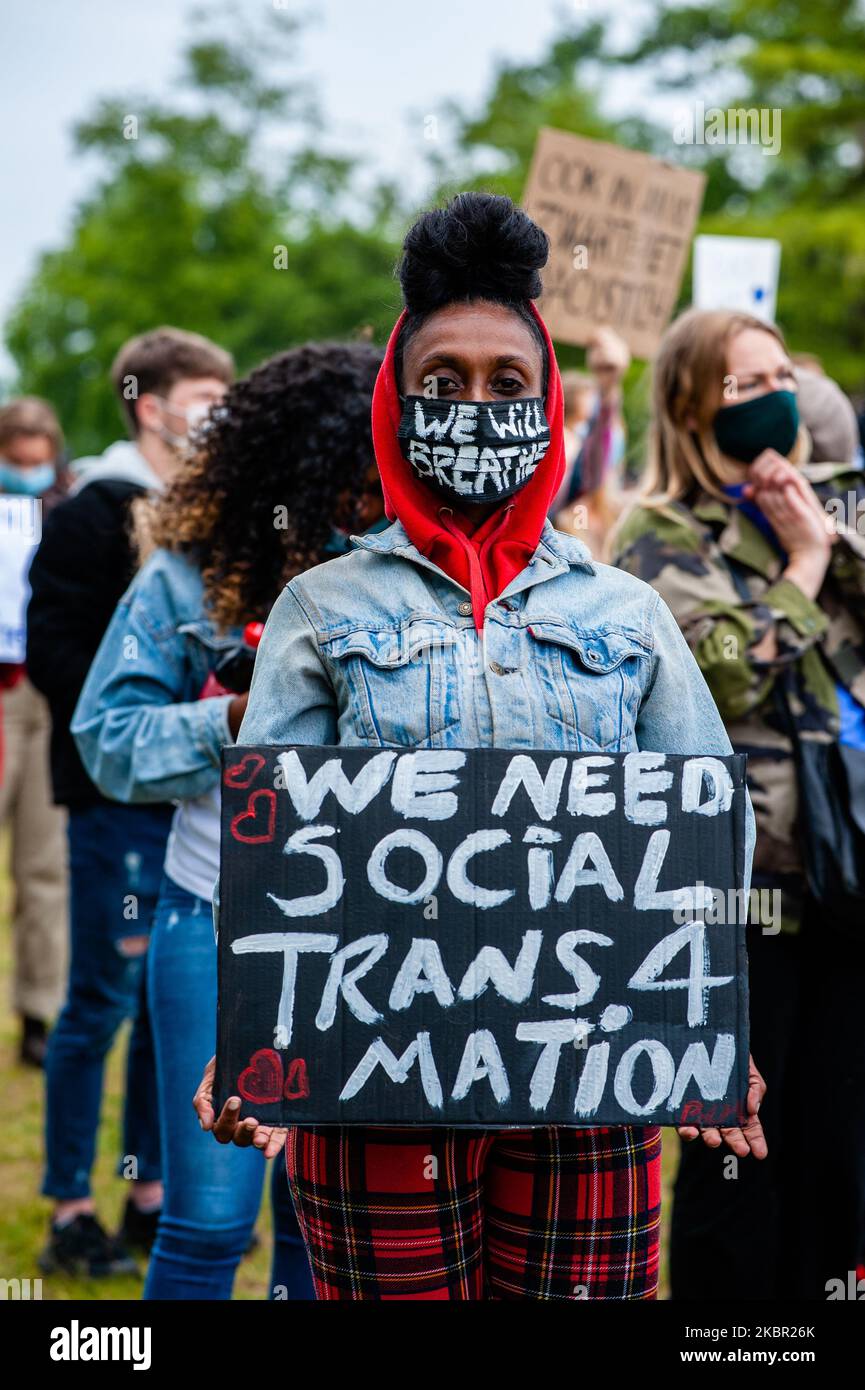 A Black woman is holding an anti racist placard, during the second ...