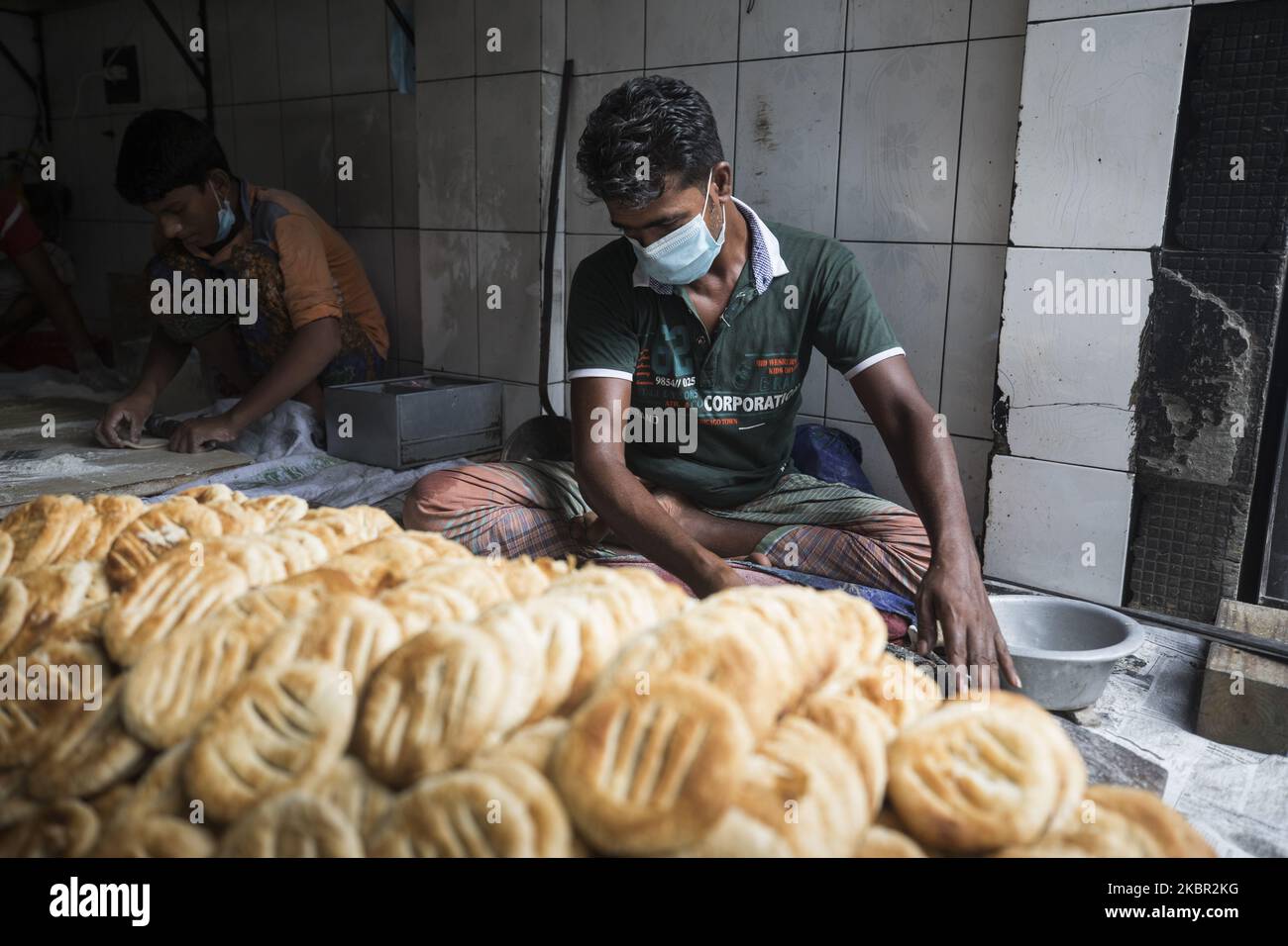 Bakers make Bakarkhani at a street side shop in old Dhaka on June 11 ...