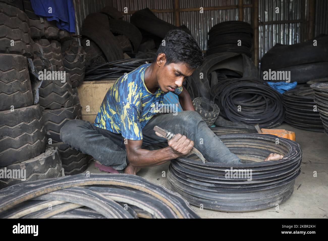 Young laborer cuts strips of rubber hi-res stock photography and images ...