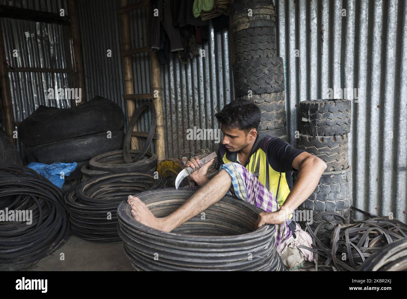 Young laborer cuts strips of rubber hi-res stock photography and images ...