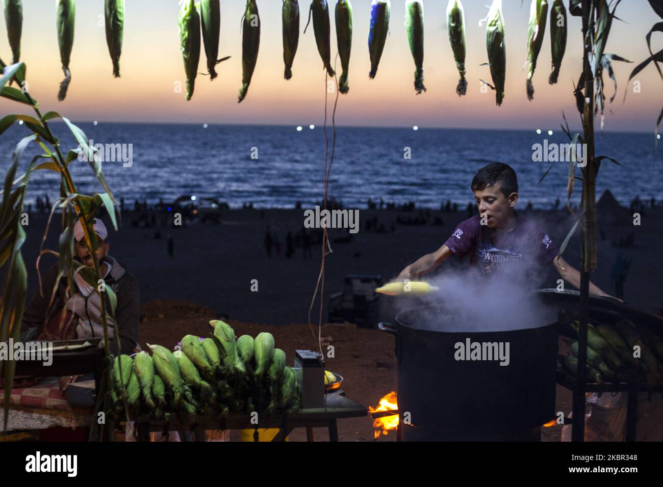 A Palestinian boy Mohammed Naser 10 years old, sells corn at Gaza Beach during sunset, on 11 ...