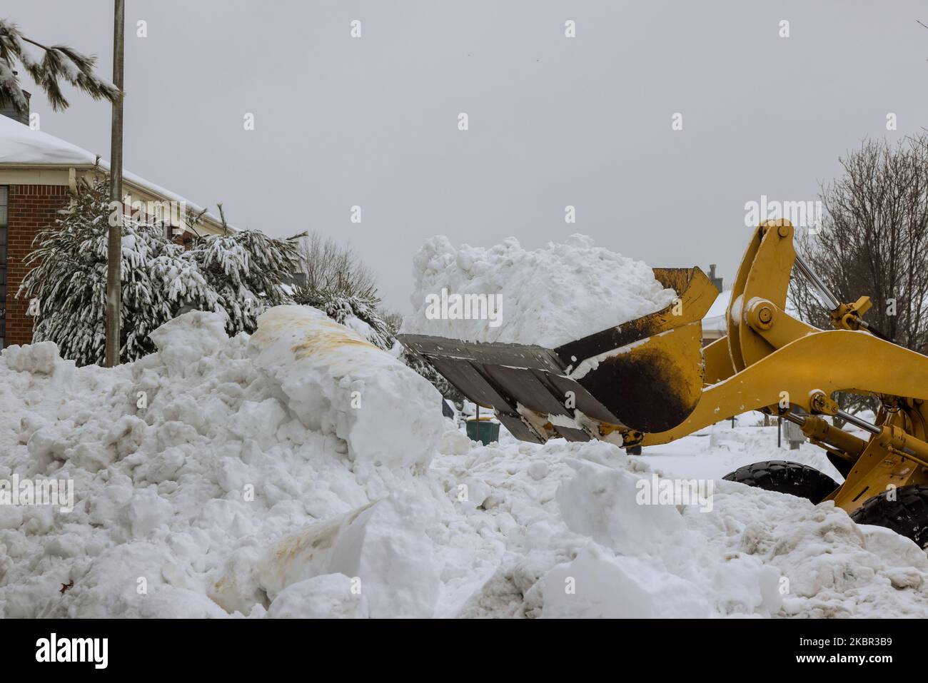 Snow blizzard in wintertime with snow being cleared out with tractor ...