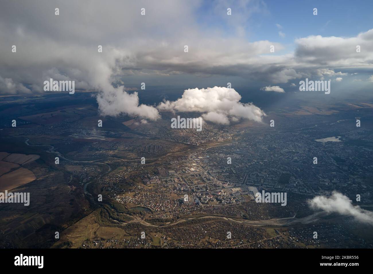 Aerial view from airplane window at high altitude of distant city ...