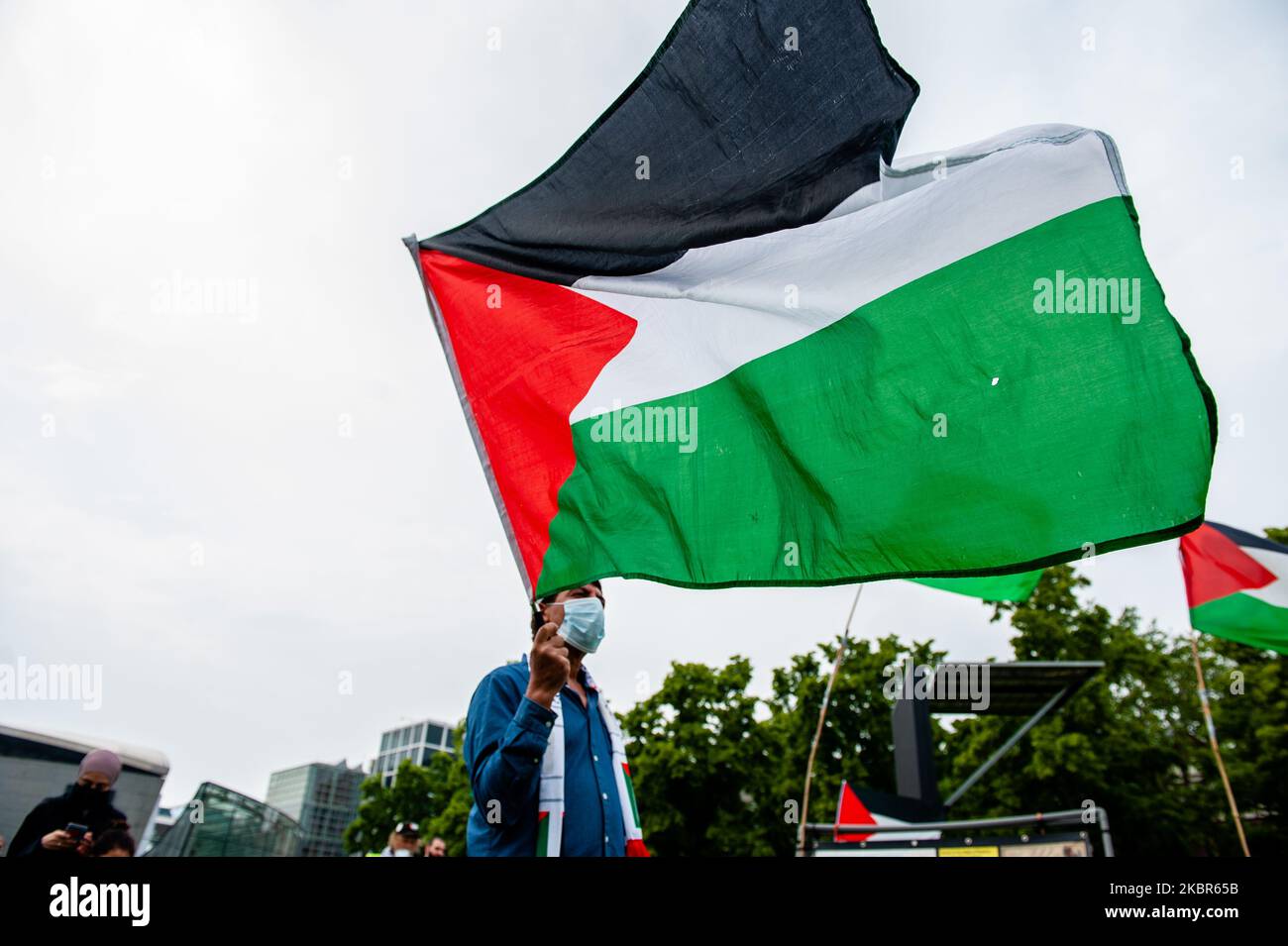 A man is raising a big Palestinian flag, during the demonstration in ...