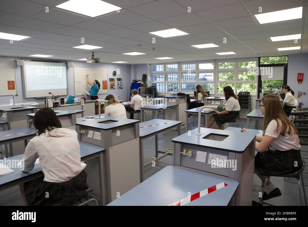 A teacher at the front of the class teaching a group of Year 10 pupils ...