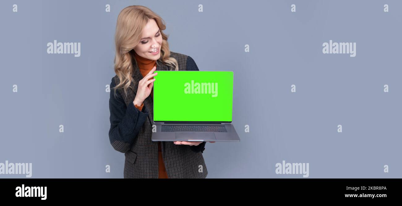 Business woman look at laptop with blank neon green screen for copy ...