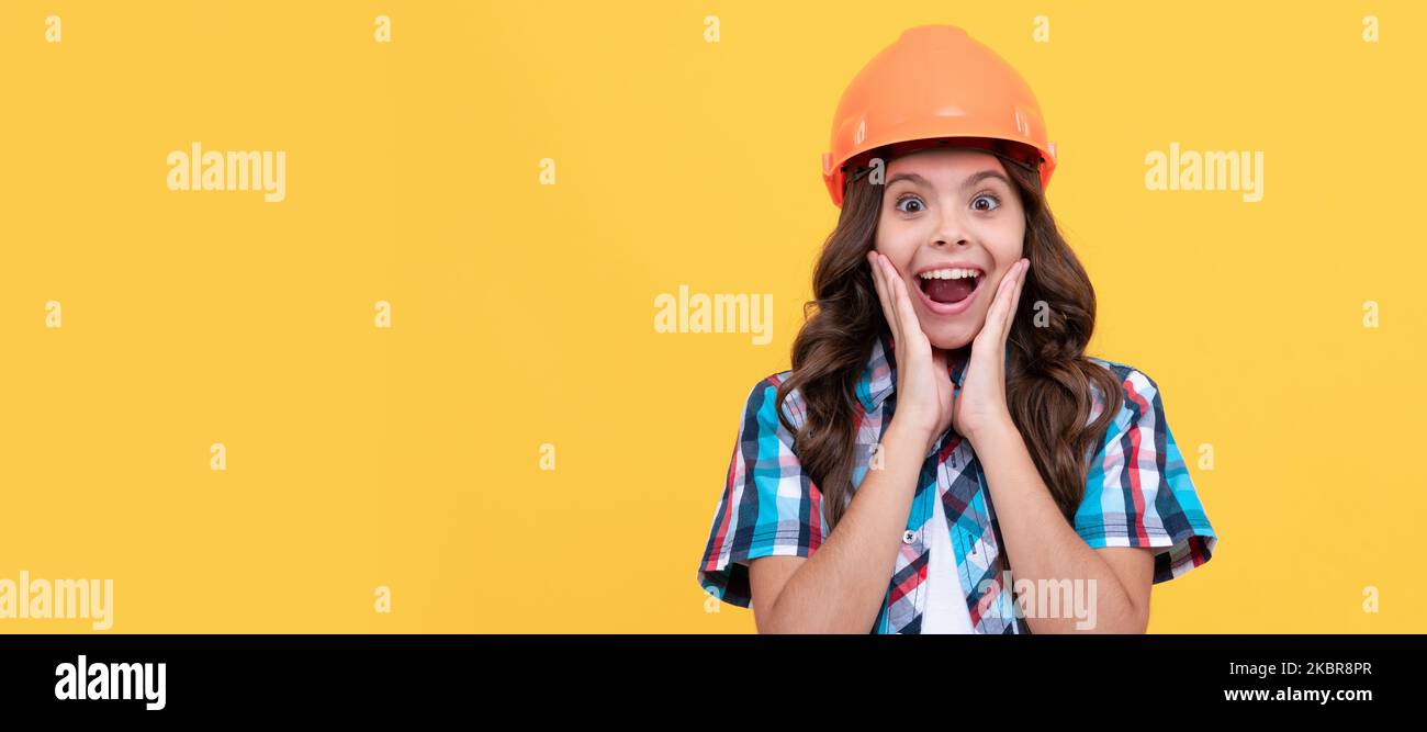 Renovation child, amazed kid with curly hair in construction helmet ...