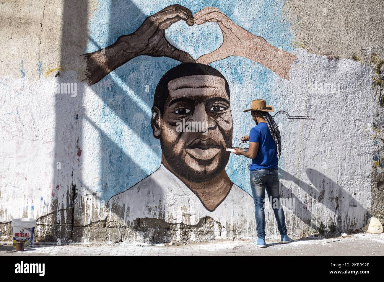 A Palestinian artist Ayman Al-hossary paints a mural that depicts ...