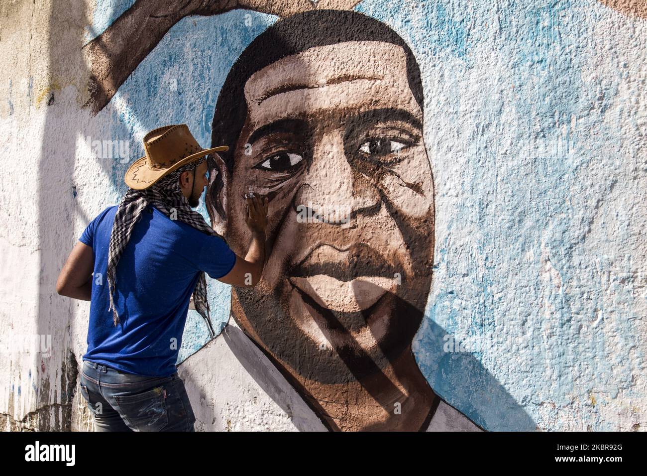 A Palestinian artist Ayman Al-hossary paints a mural that depicts ...