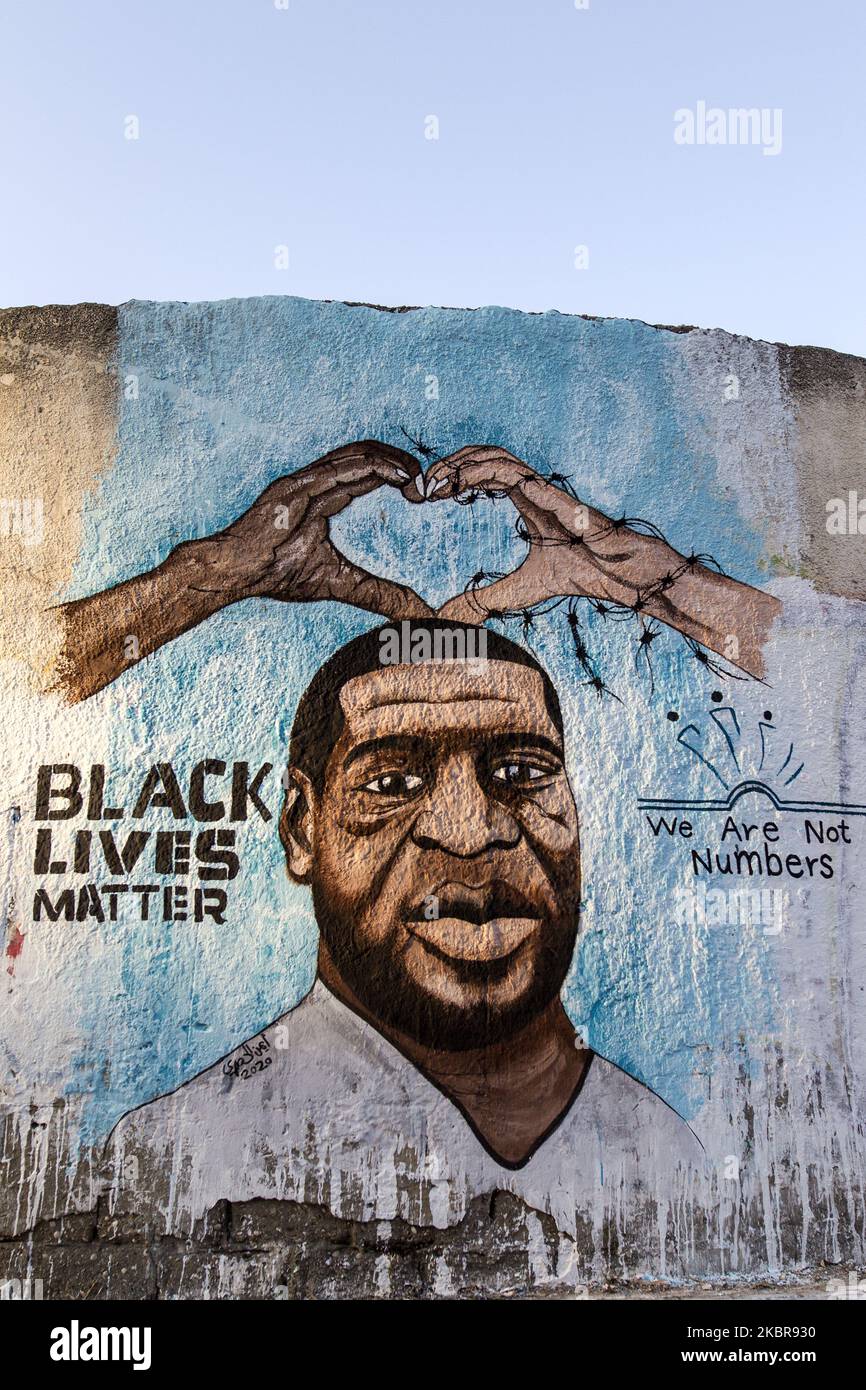 A photo is seen paints a mural that depicts George Floyd in Gaza City ...