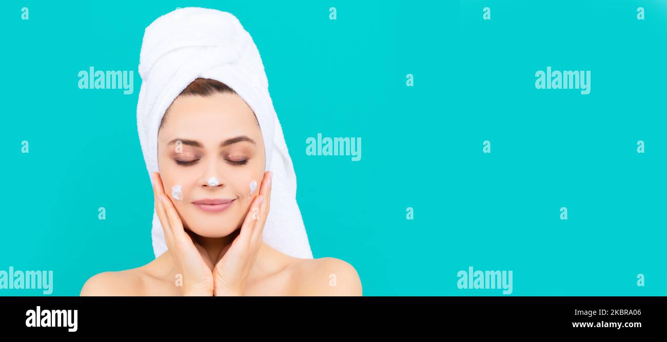 Skin care beauty woman. smiling young girl applying face cream on blue ...