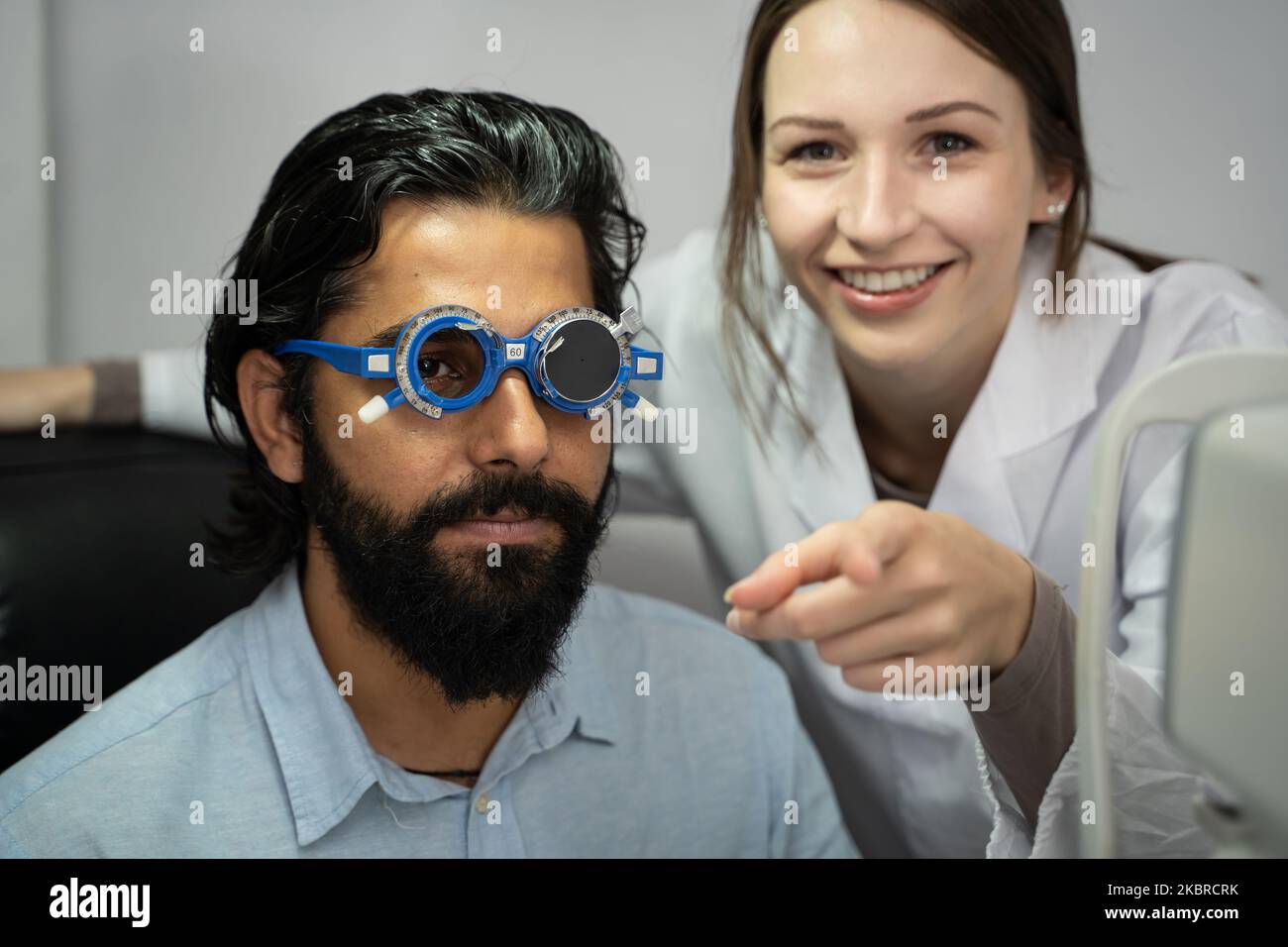 An eye doctor examines a male patient in a clinic with modern equipment ...