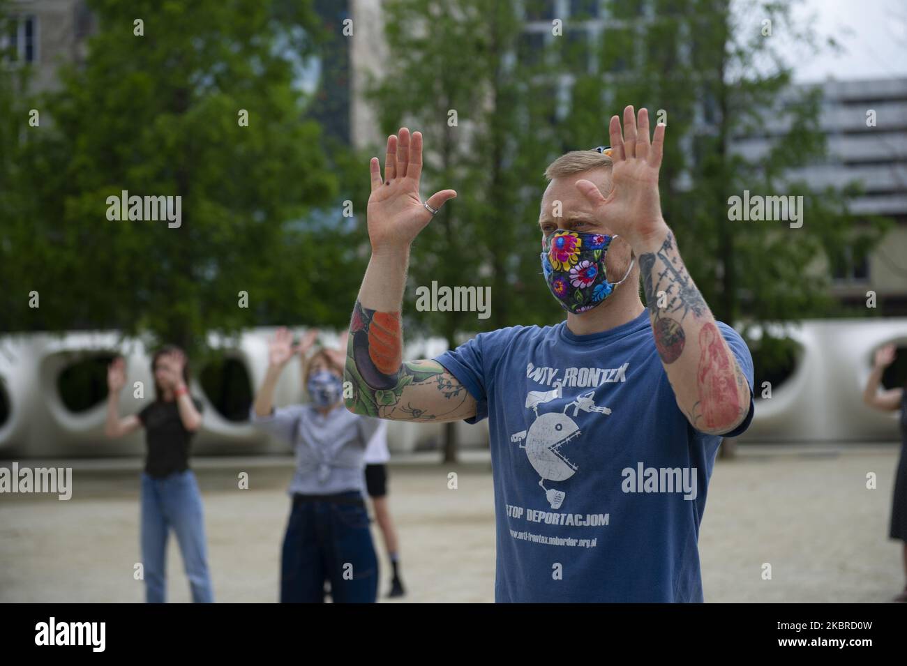 Demonstrators are seen performing in front of the Frontex headquarter ...