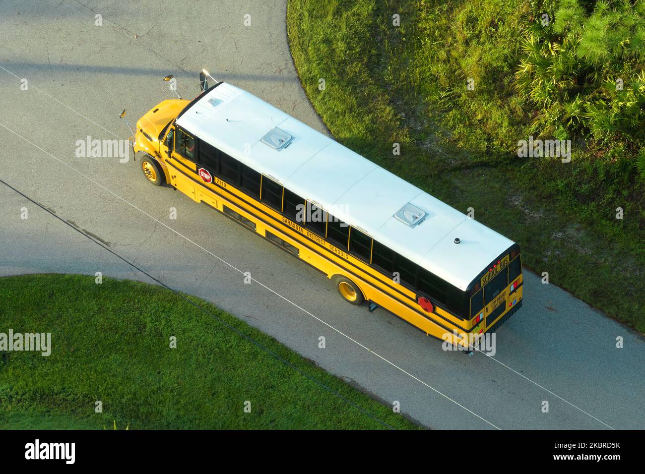 Aerial view of american yellow school bus driving on suburban street ...