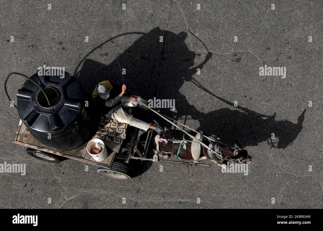 A man rides a donkey-drawn cart on a street in Gaza City on June 21 ...