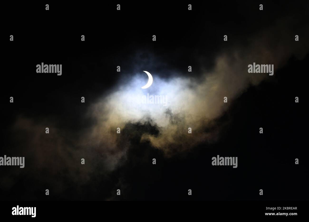 The sun is seen through rain clouds during solar eclipse in Kathmandu ...