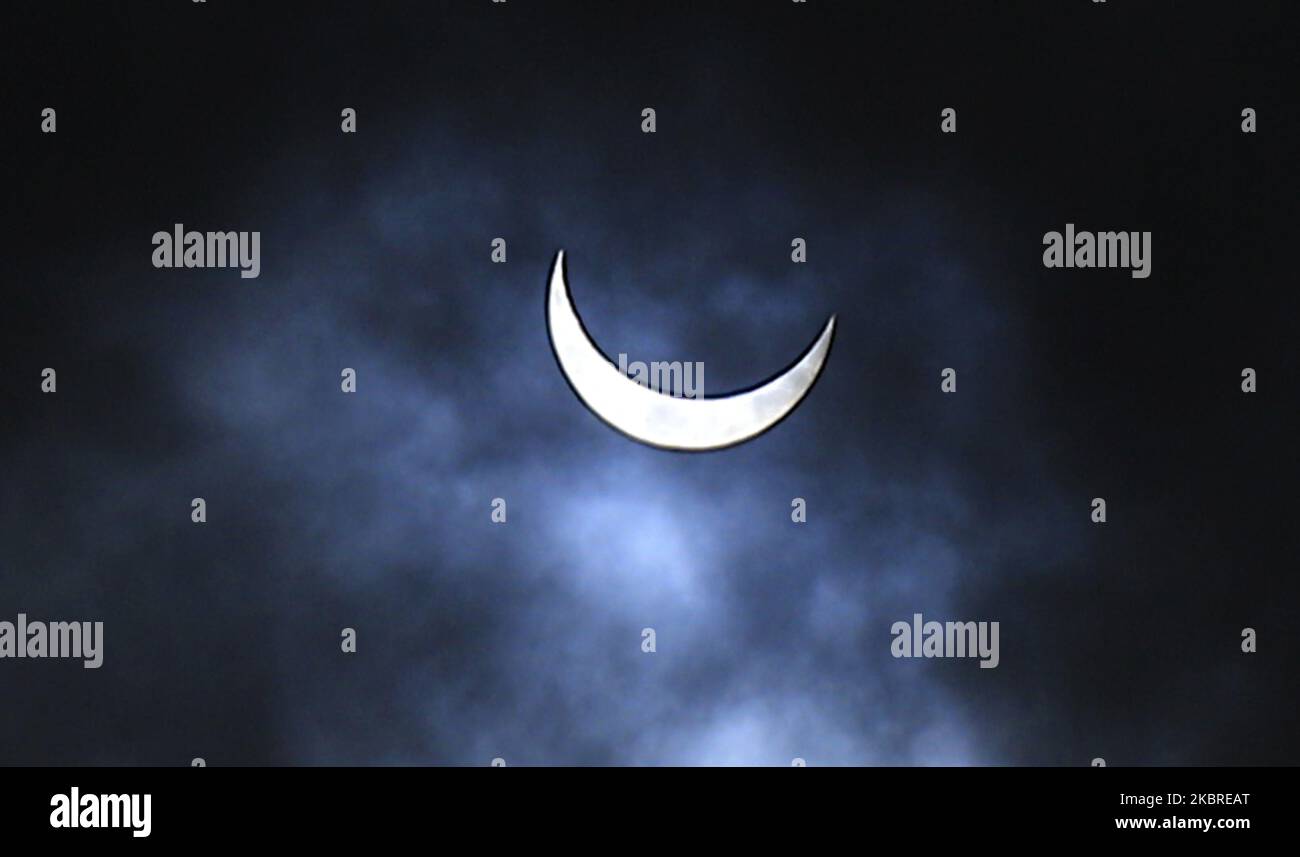 The sun is seen through rain clouds during solar eclipse in Kathmandu ...