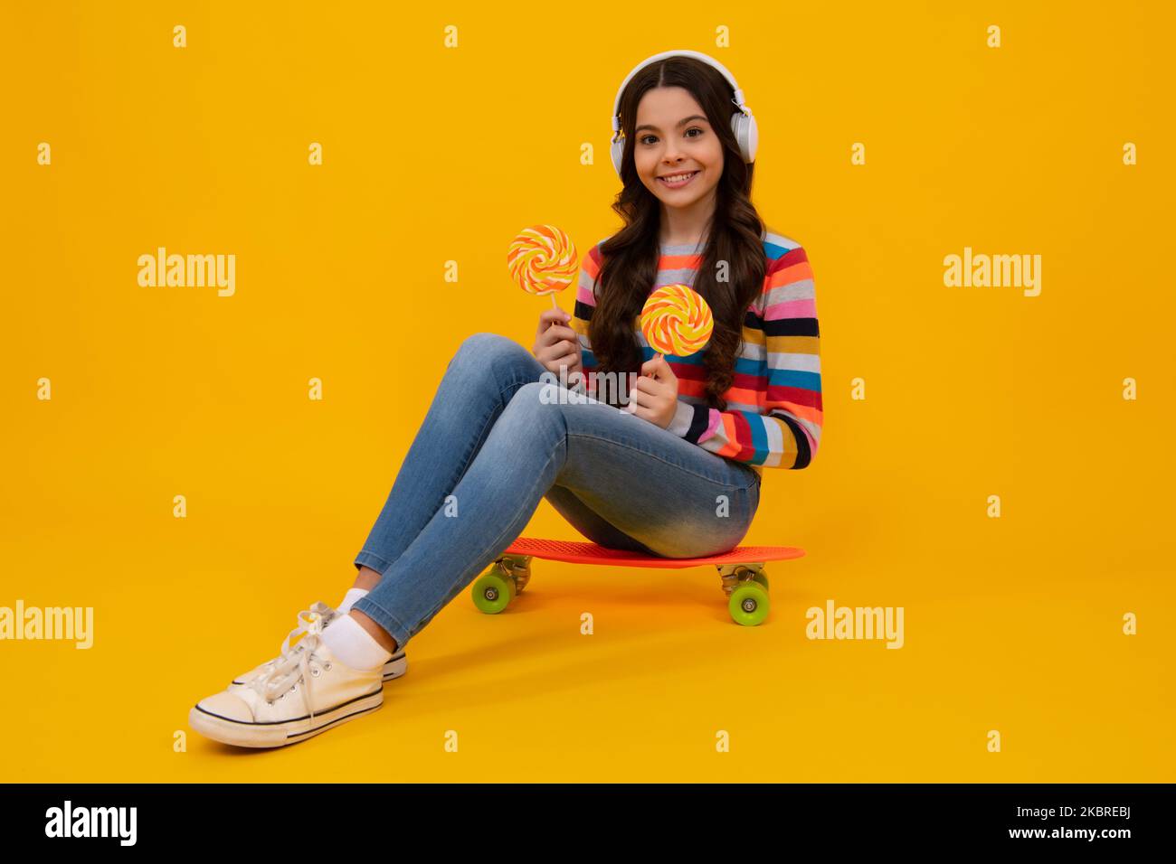 Funny child with lollipop over yellow isolated background. Sweet ...