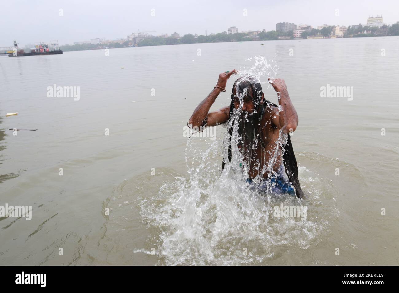 Hindu devotees sit in the Ganges River during an annular solar eclipse ...