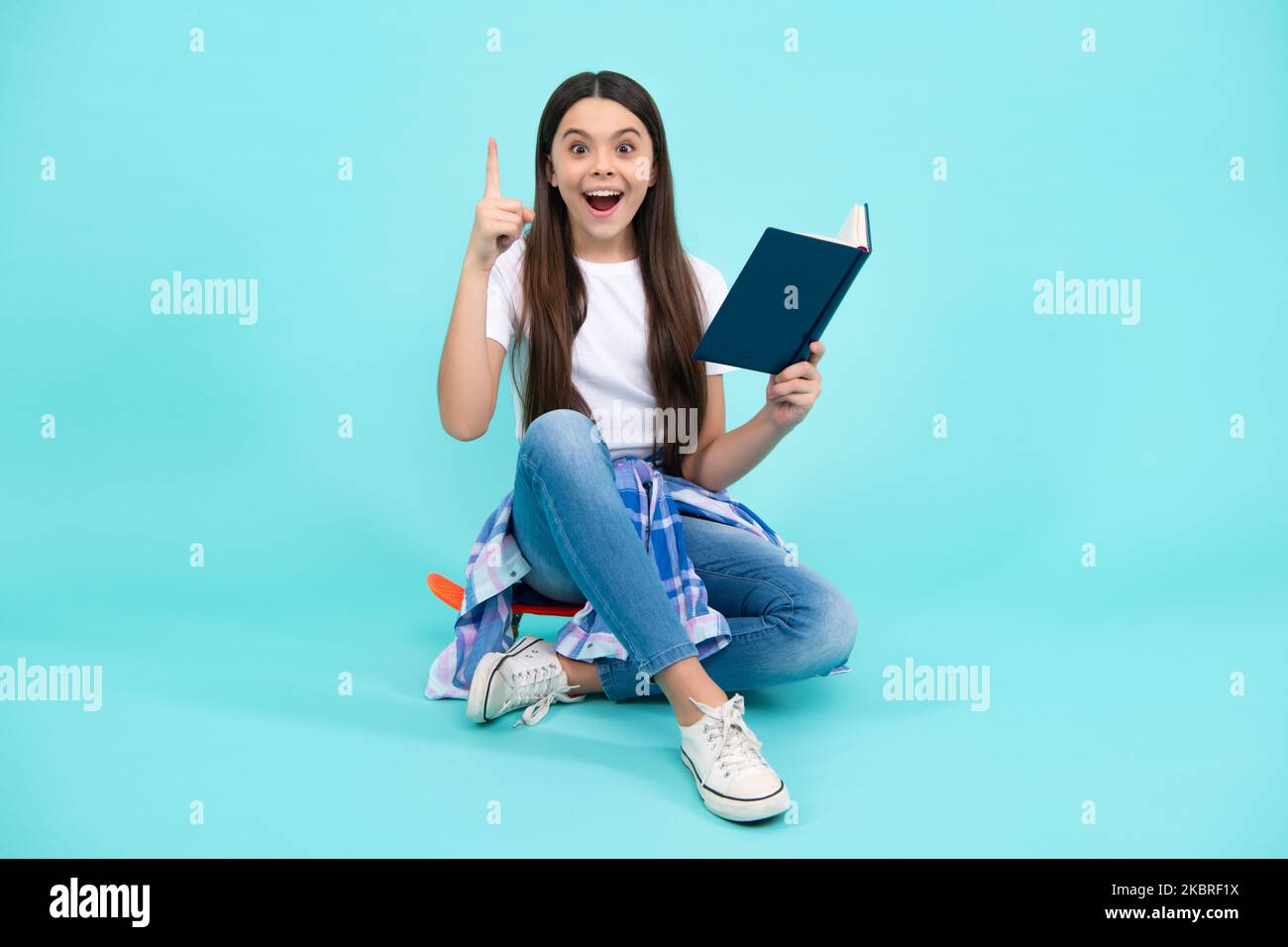 Amazed teenager. Schoolgirl with copy book posing on isolated ...