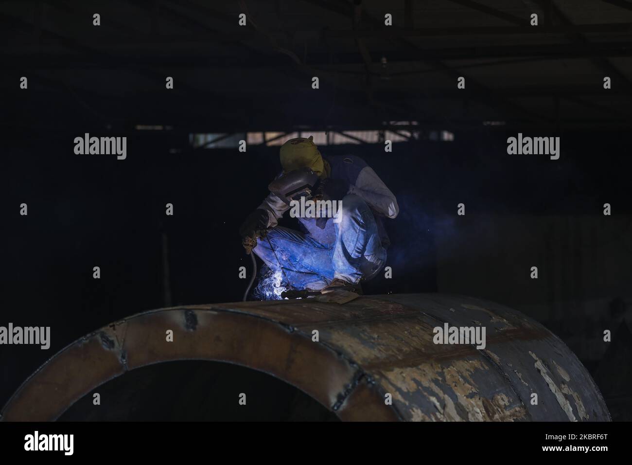 A worker weld a part on steel structures at a workshop in Dhaka on June ...