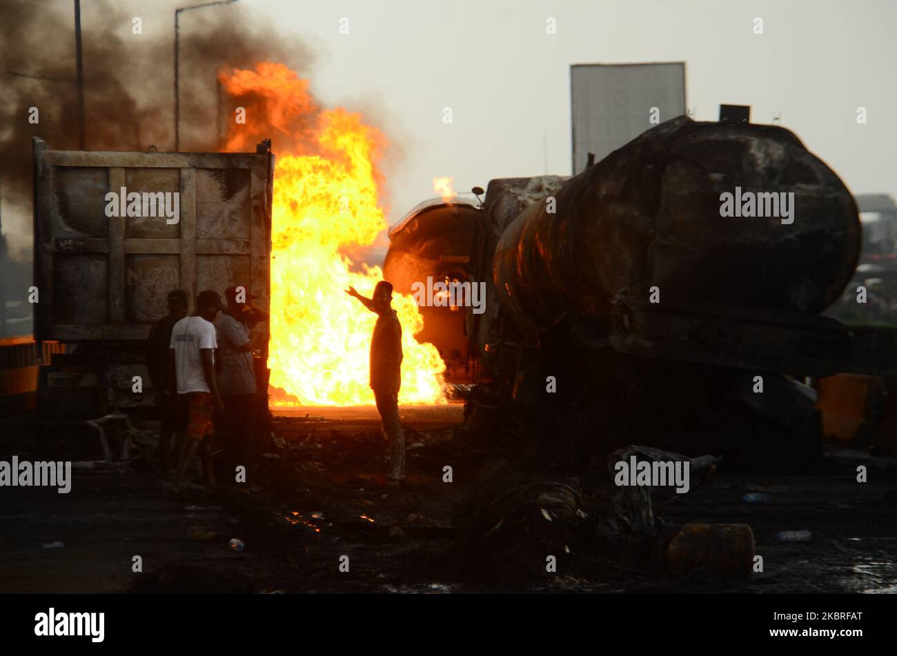 A man stand in between a burning fire during a tanker explosion ...