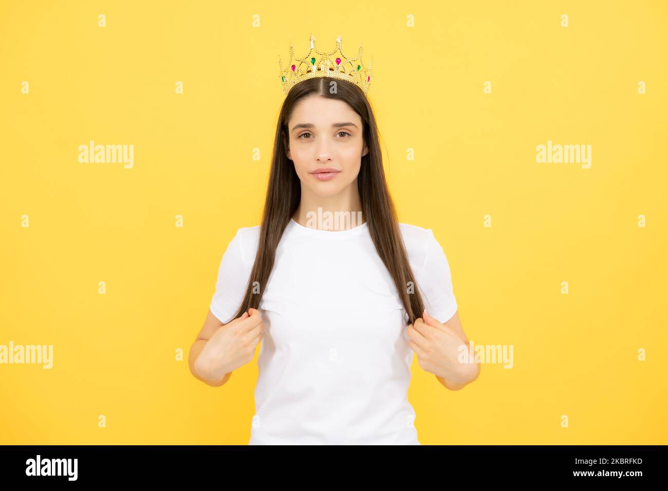 Young lovely woman in crown on yellow background. Girl with queen crown ...