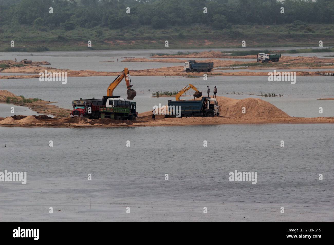 Sand digging machines are seen inside the 'Kuakhai' river and load ...
