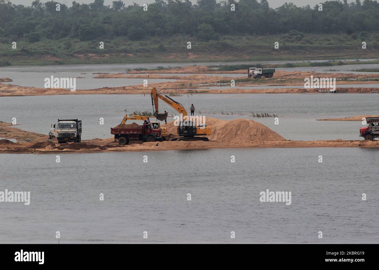 Sand digging machines are seen inside the 'Kuakhai' river and load ...