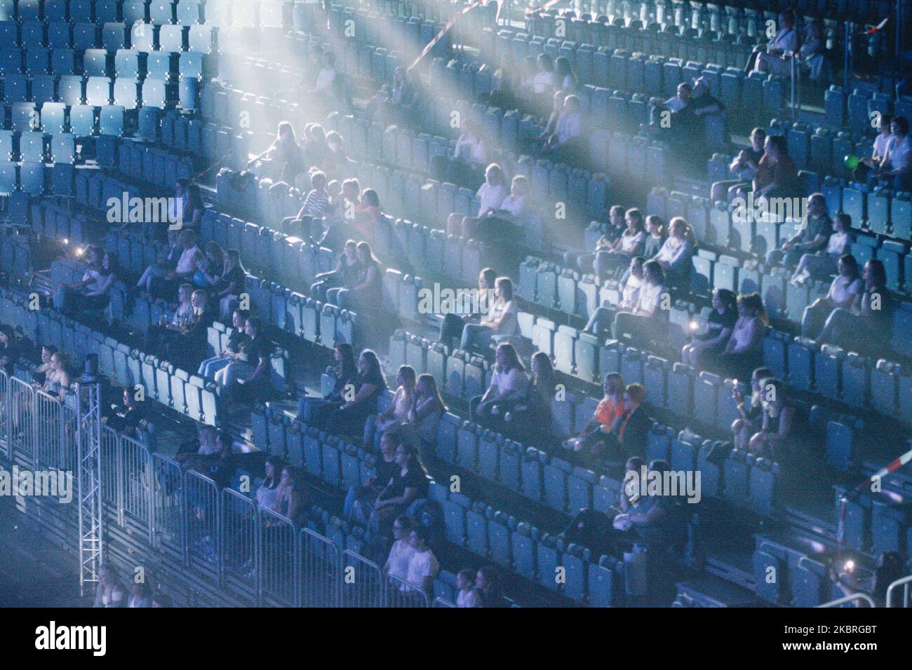 fans sit apart from each other in order to keep social distance during ...