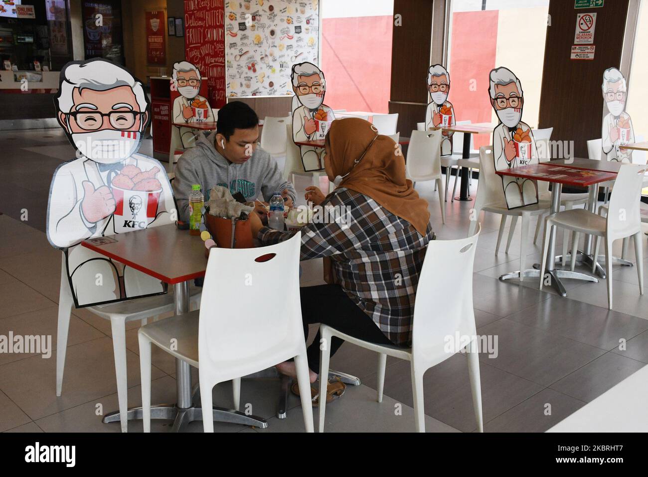 Waiters tidy up tables and draw KFC (Kentucky Fried Chicken) characters ...