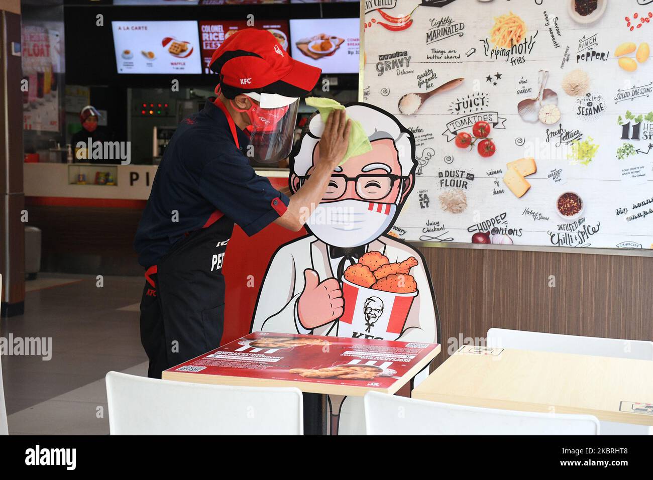Waiters tidy up tables and draw KFC (Kentucky Fried Chicken) characters ...